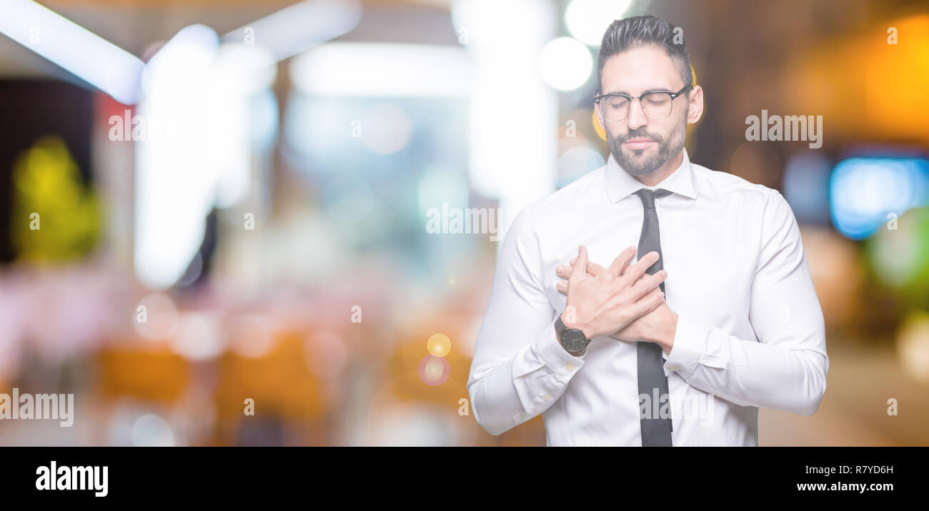 Young handsome business man wearing glasses over isolated background ...