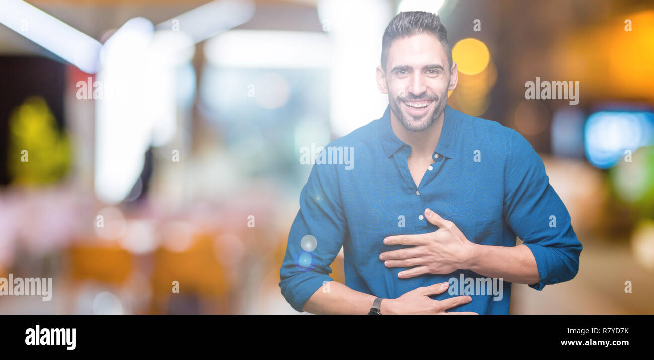 Young handsome man over isolated background Smiling and laughing hard ...