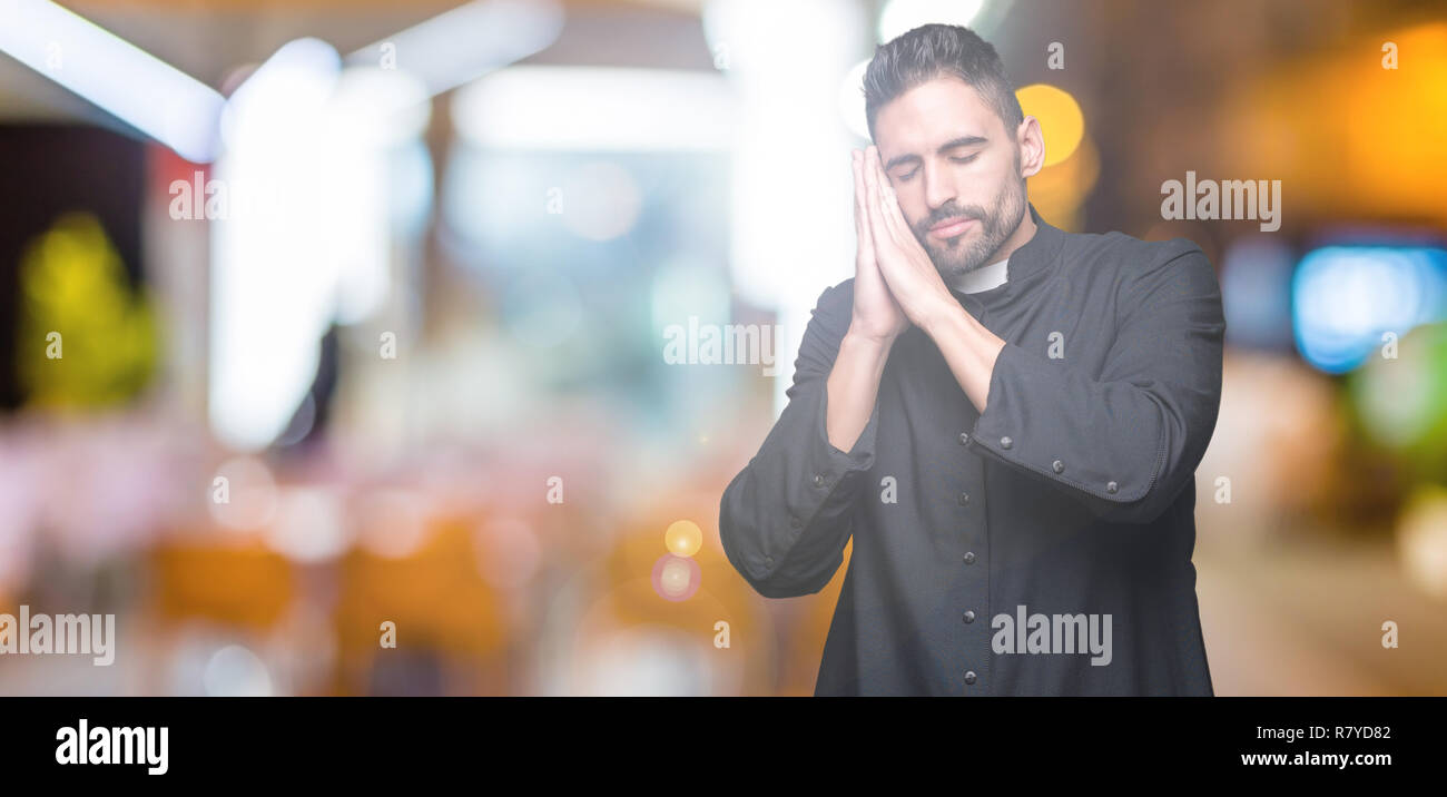 Young Christian priest over isolated background sleeping tired dreaming ...