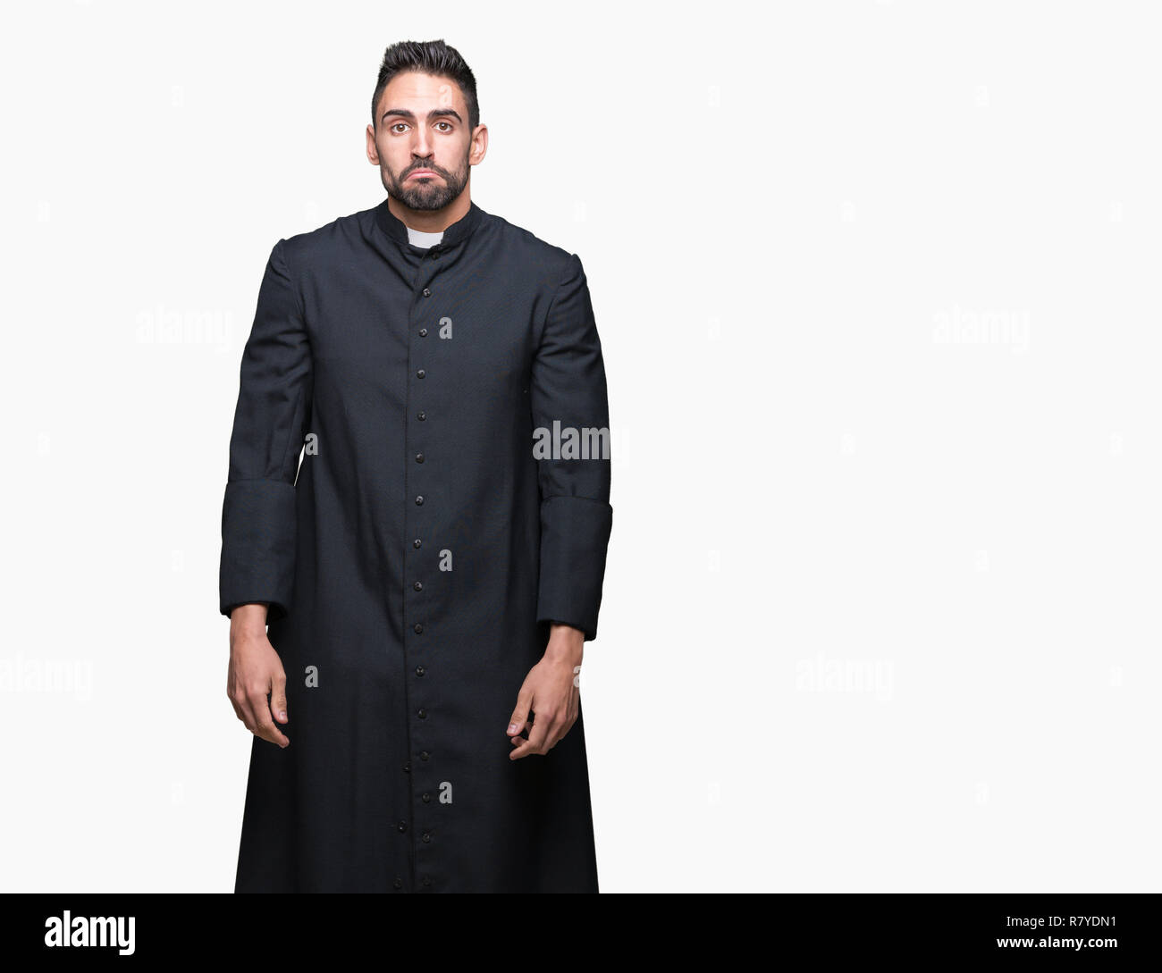 Young Christian priest over isolated background depressed and worry for ...