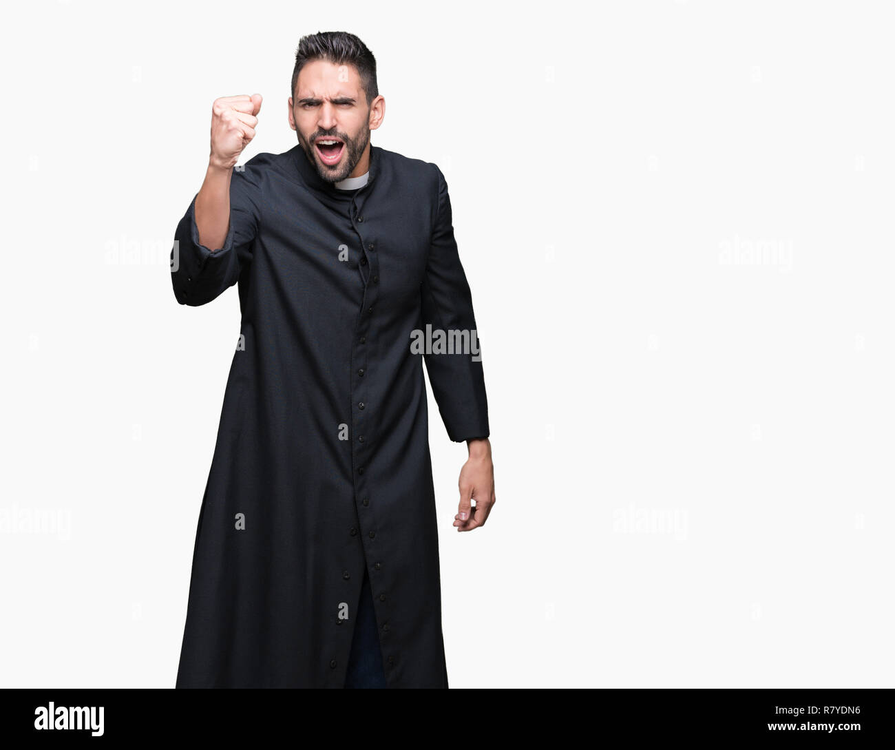 Young Christian priest over isolated background angry and mad raising ...