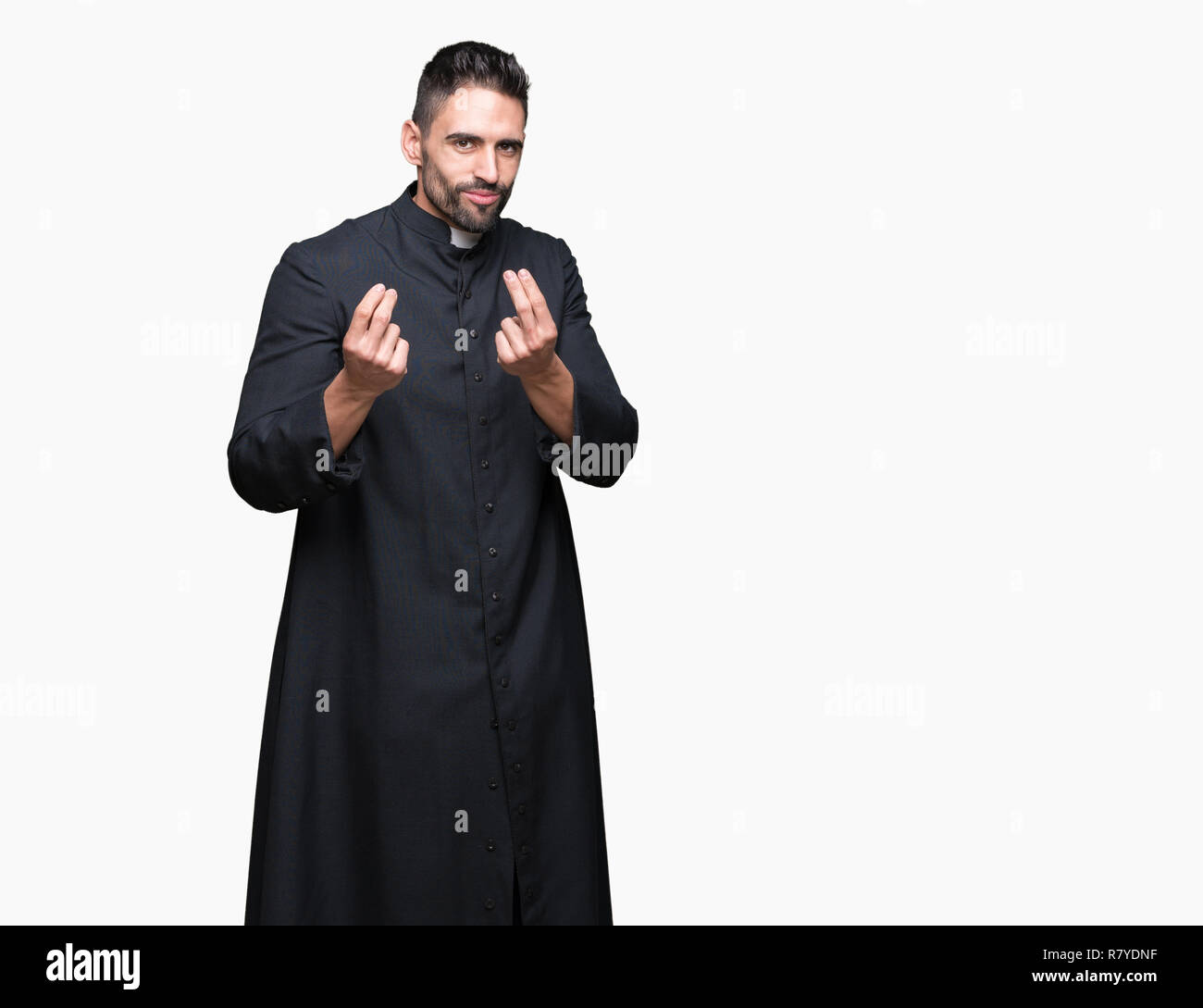 Young Christian priest over isolated background Doing money gesture ...