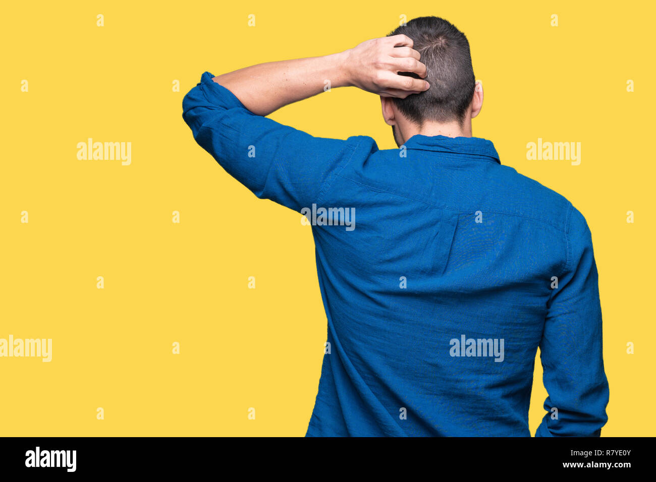 Young handsome man over isolated background Backwards thinking about ...