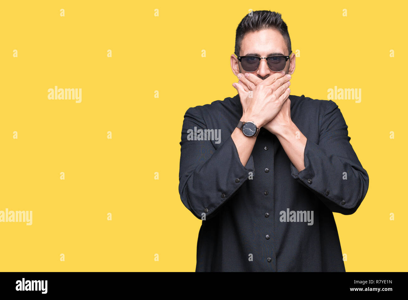 Young Christian priest wearing sunglasses over isolated background ...