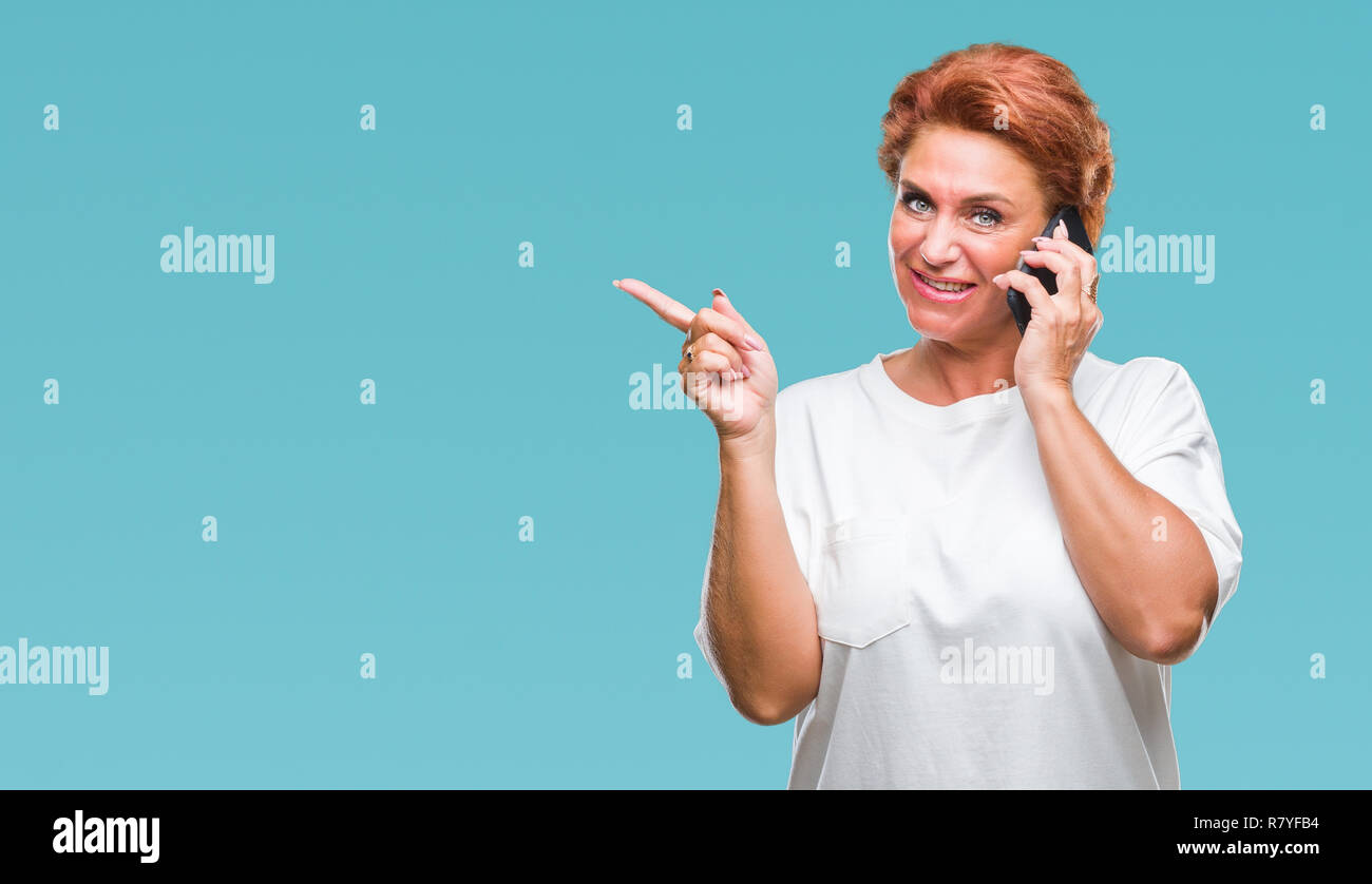 Atrractive senior caucasian redhead woman talking on smartphone over ...