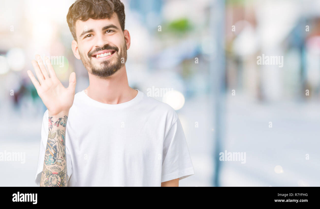 Young handsome man wearing white t-shirt over isolated background ...