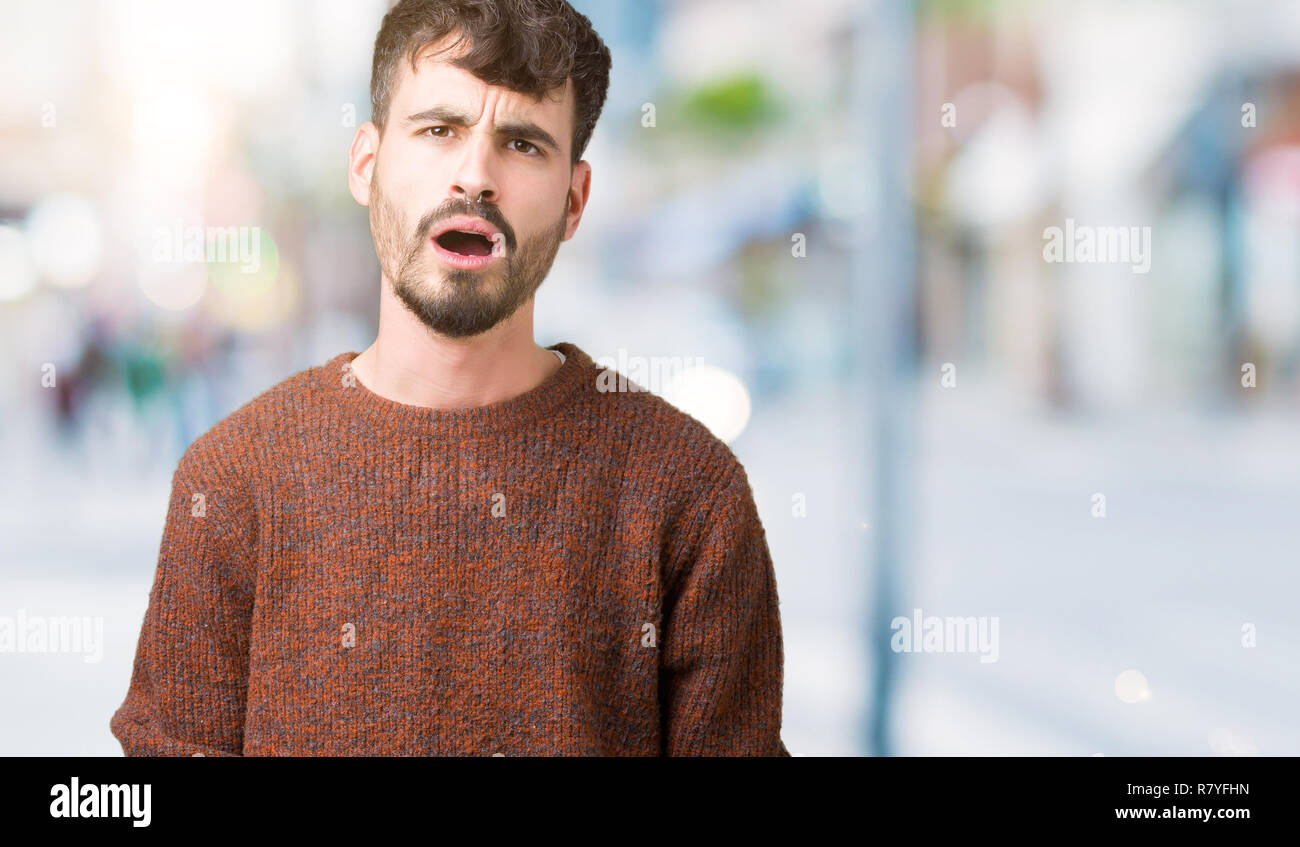 Young handsome man wearing winter sweater over isolated background In ...