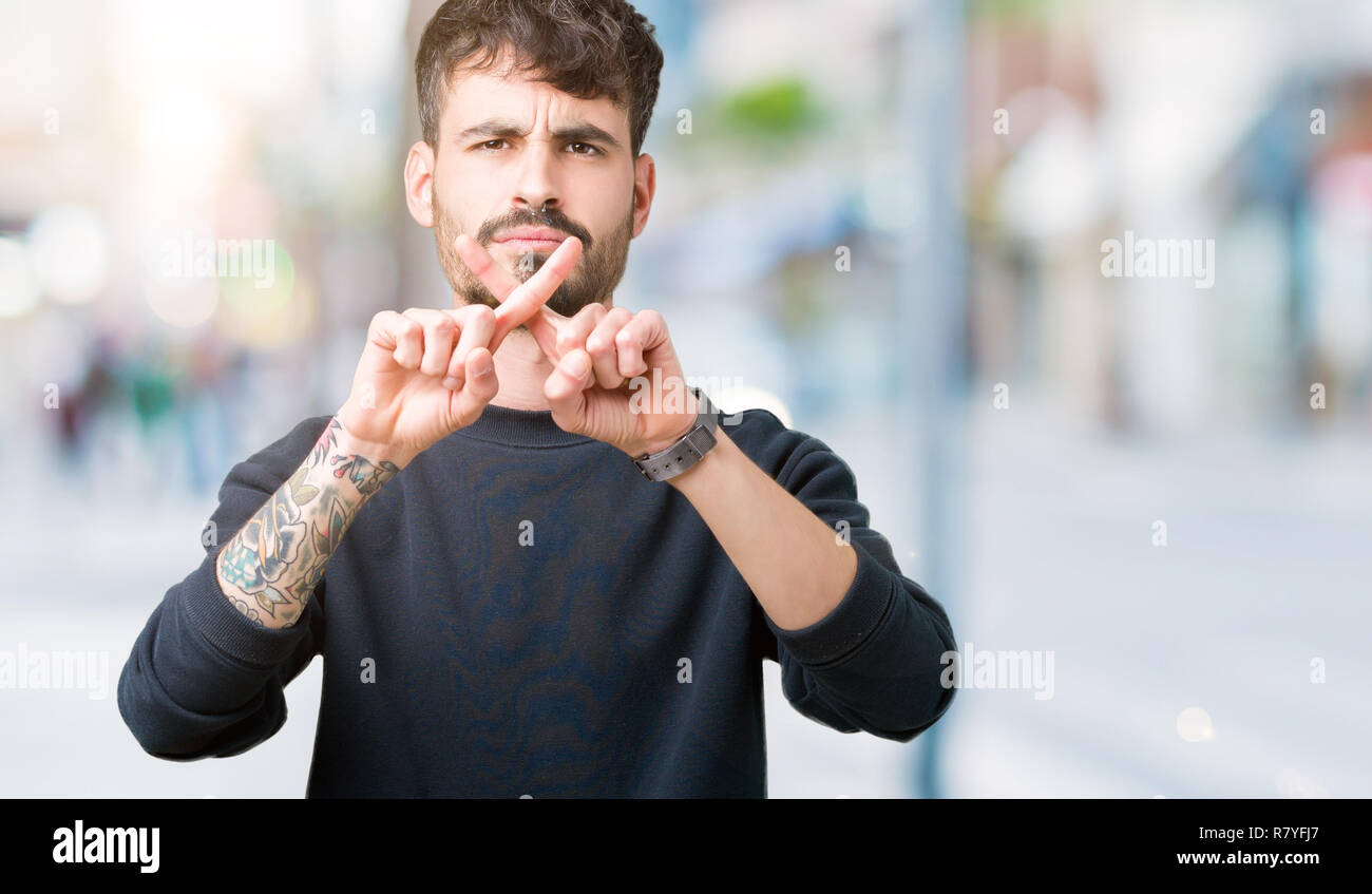 Young handsome man over isolated background Rejection expression ...