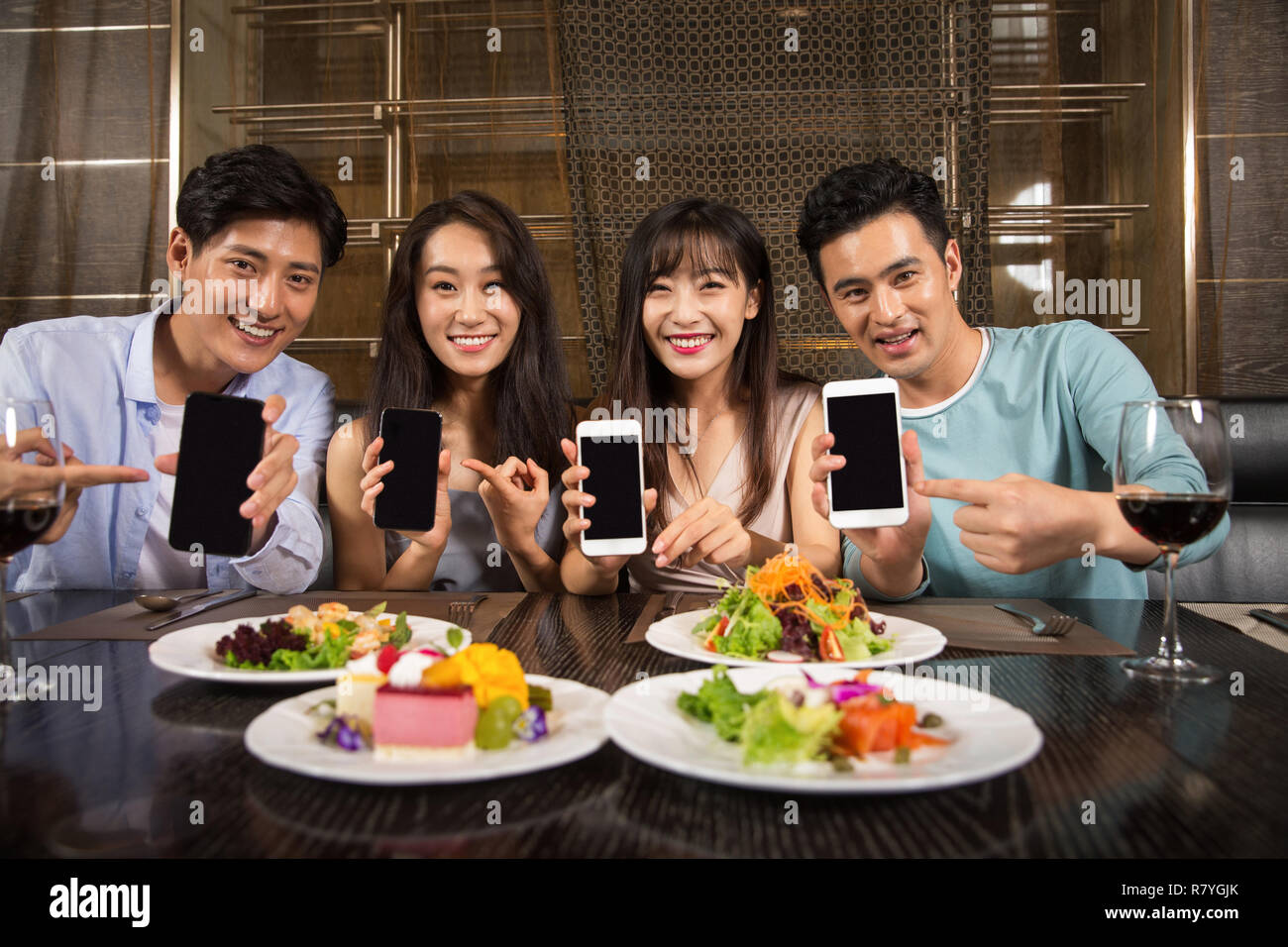 Young men show a mobile phone Stock Photo - Alamy