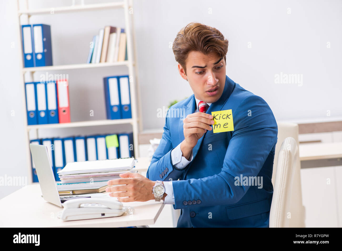 Office prank with kick me message on sticky note Stock Photo - Alamy