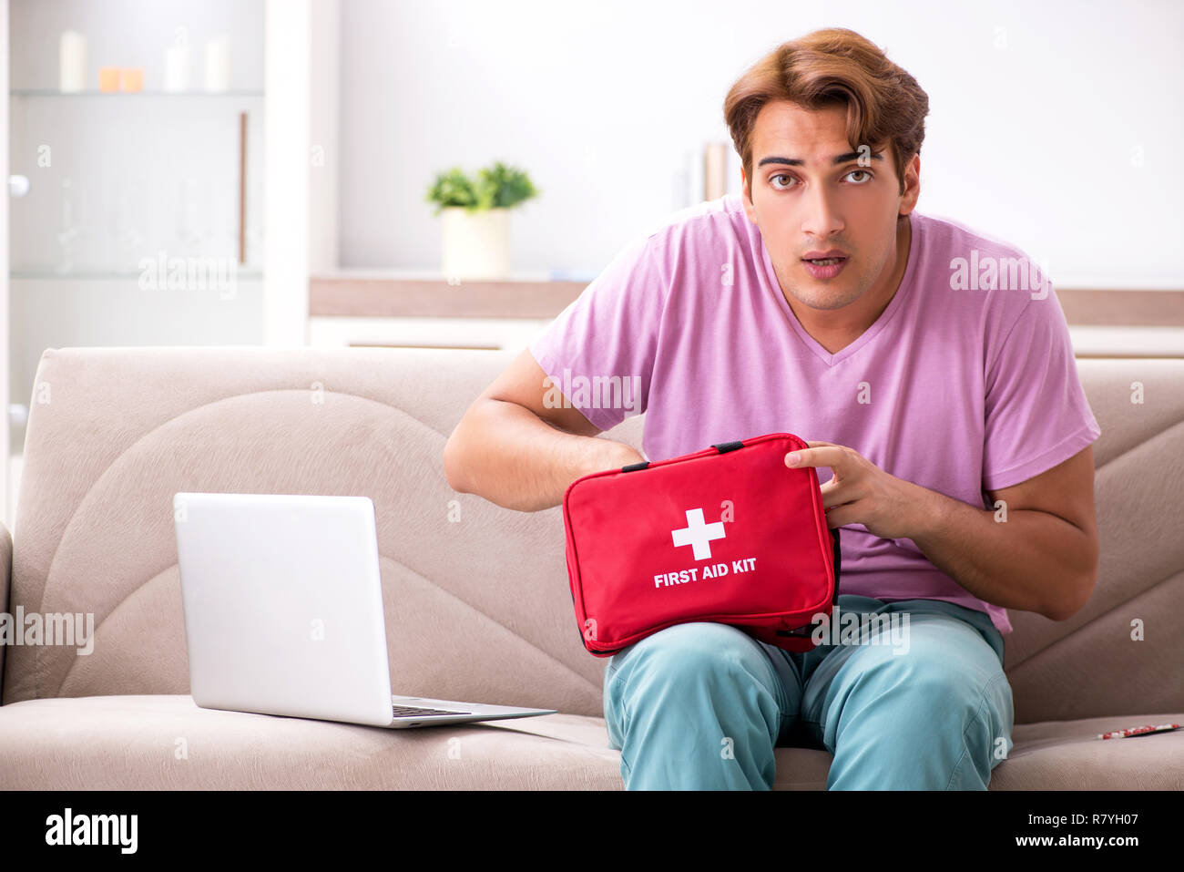 Sick man at home with first aid kit Stock Photo - Alamy