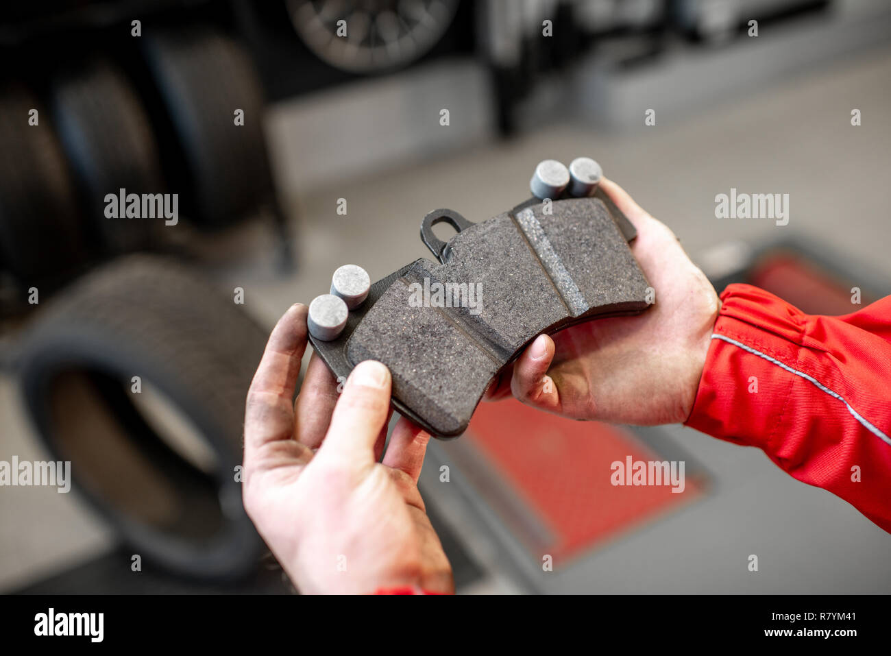 Auto mechanic holding new brake pad at the car service, close-up view ...