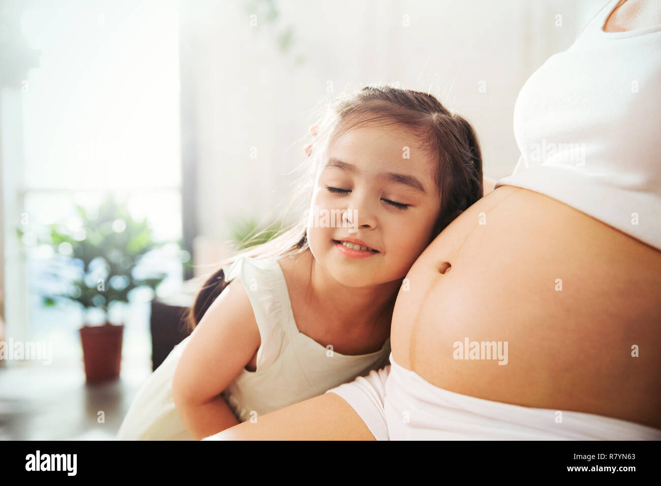 The pregnant mother and the little girl Stock Photo - Alamy