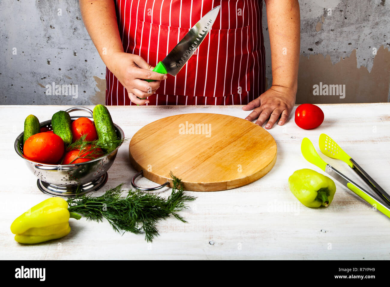 Woman in a red apron holding a knife in the kitchen. Cooking Stock ...