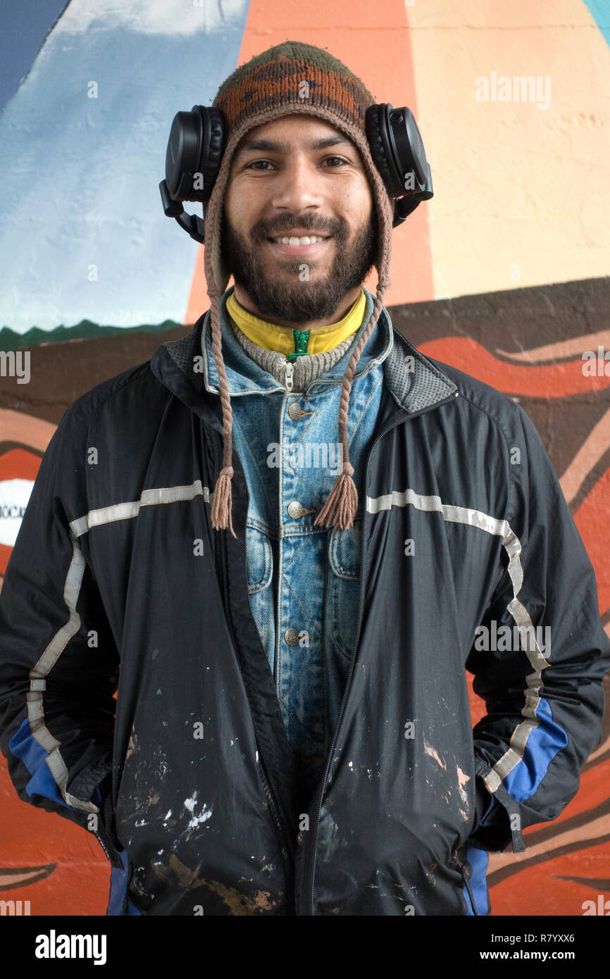 Jordan Hamilton with headphones in front of his mural in progress under ...