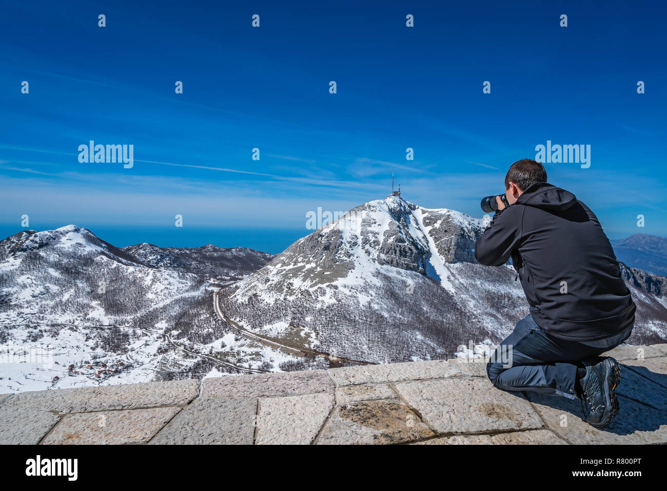 Tourist taking pictures of the stunning mountain winter landscape ...