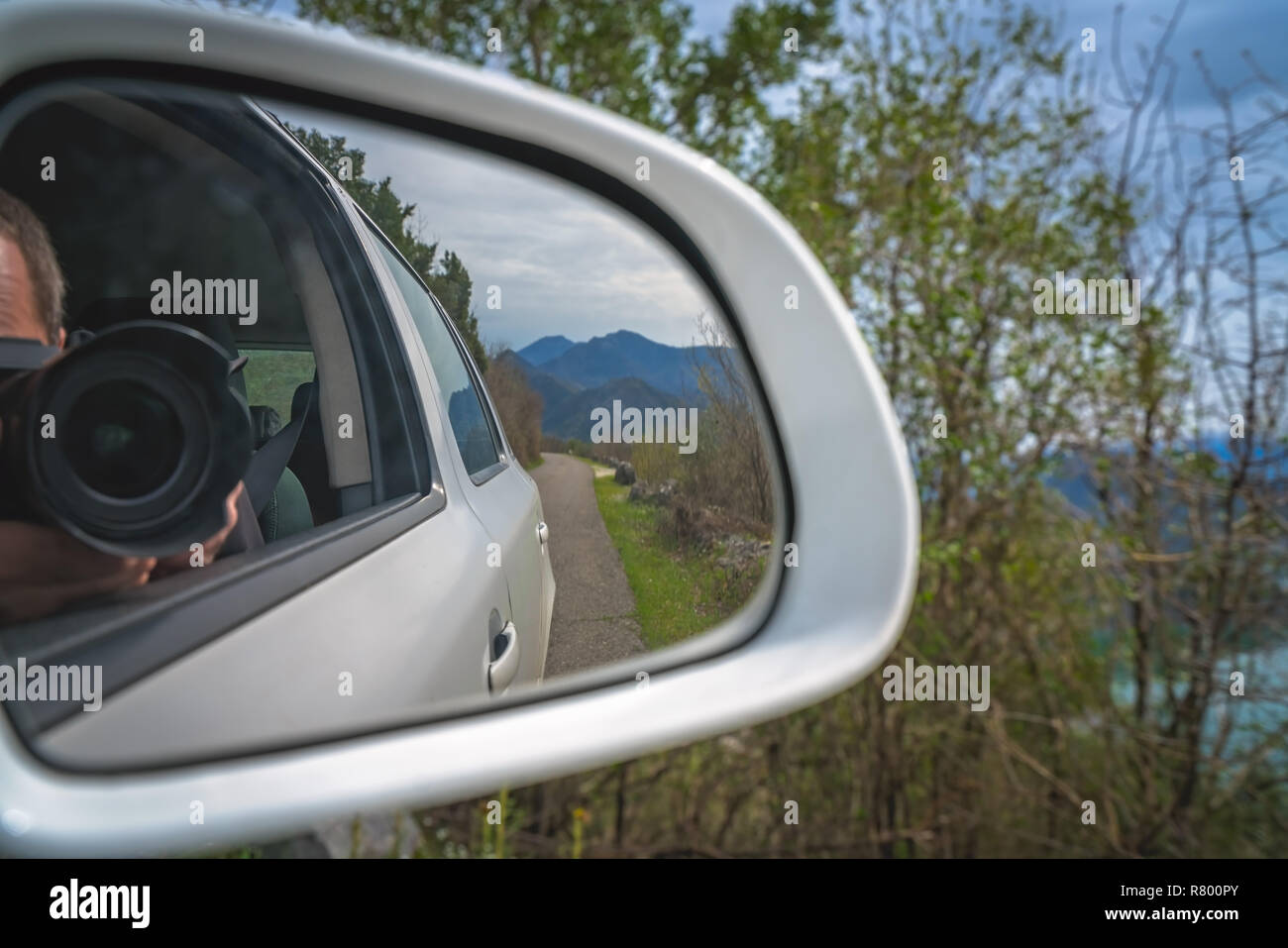 Photographer reflected in car mirror shooting pictures while driving ...
