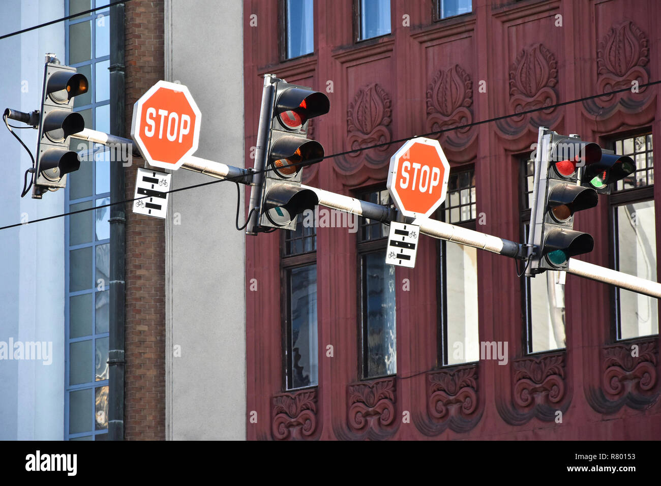Stop signs and red traffic lights at the road crossing Stock Photo - Alamy