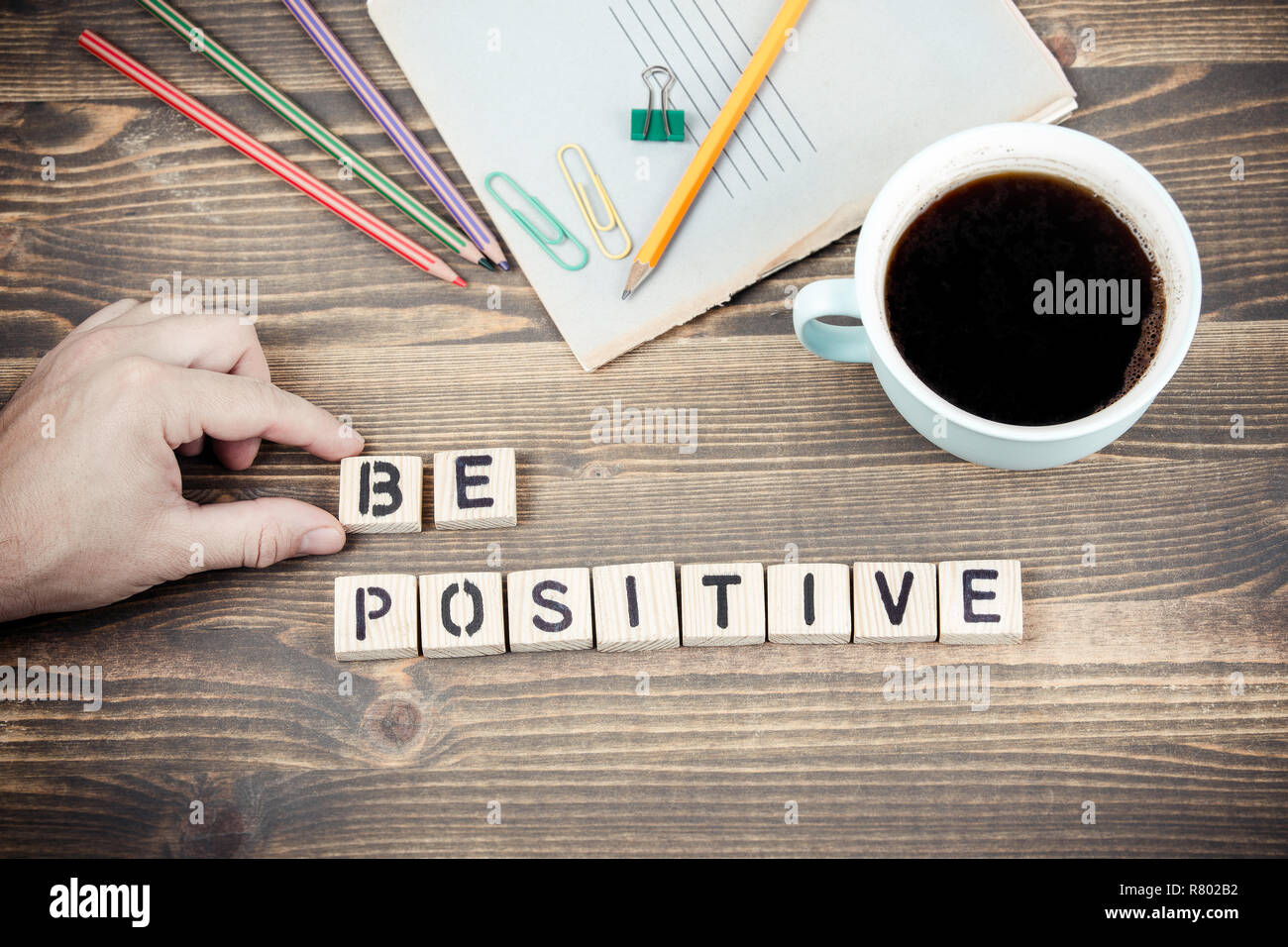 Be Positive. Wooden letters on the office desk Stock Photo - Alamy