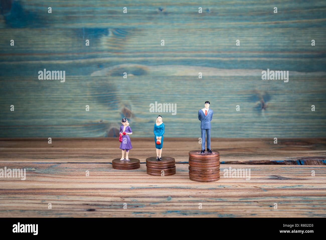 Miniature people standing on piles of coins Stock Photo - Alamy