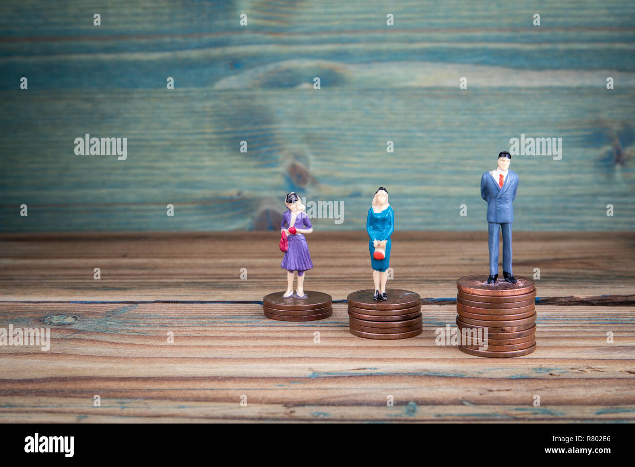 Miniature people standing on piles of coins Stock Photo - Alamy