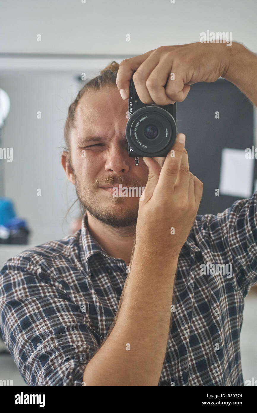 Photographer looking through camera at viewer Stock Photo - Alamy