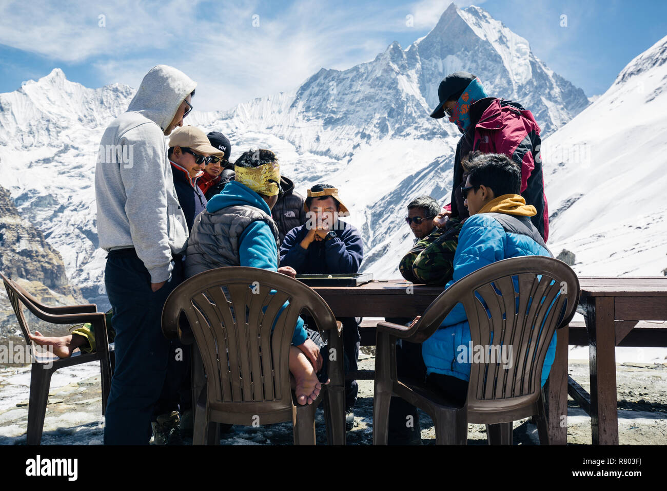 Annapurna base camp. Group of porters having free time with traditional ...
