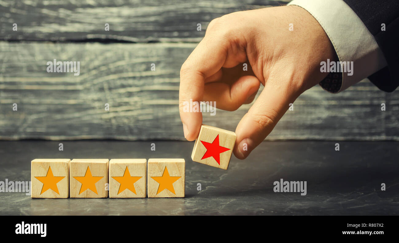 The hand of the businessman separates the fifth star from the other ...