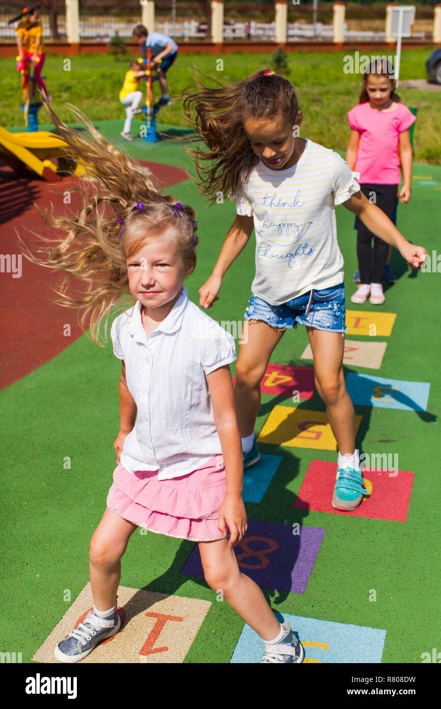 the girlfriends have fun playing hopscotch outdoors in the summer Stock ...