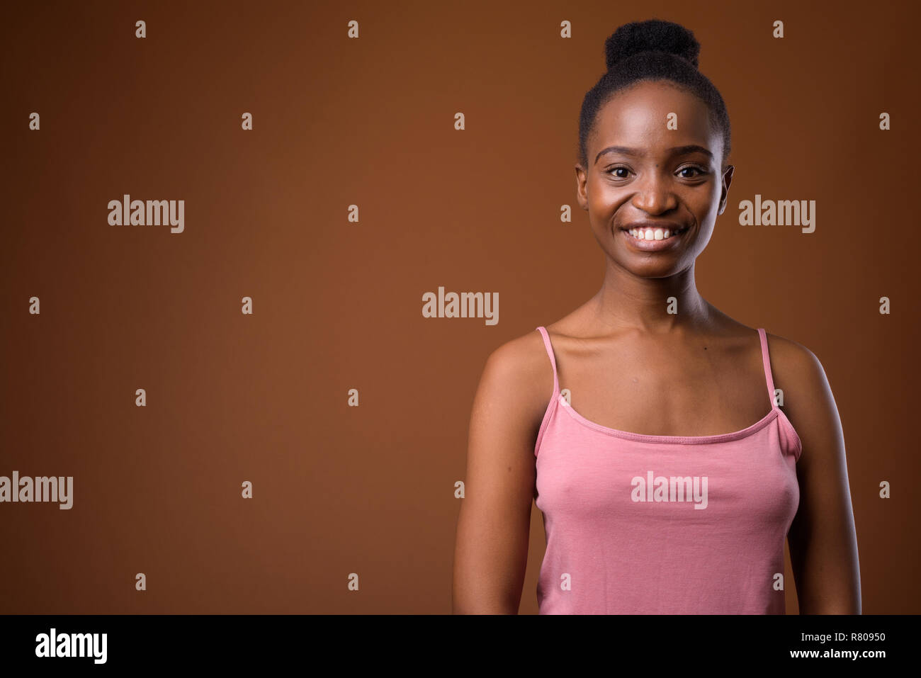 Happy African Zulu woman smiling against brown background Stock Photo ...