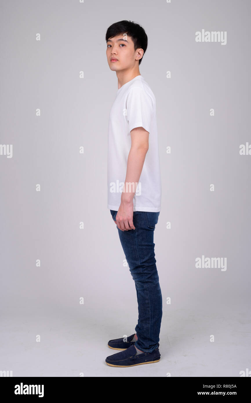Full body shot profile view of young Asian man looking at camera Stock ...