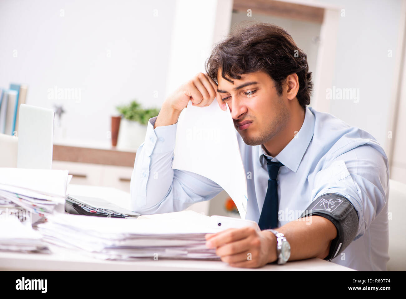 Man under stress measuring his blood pressure Stock Photo - Alamy