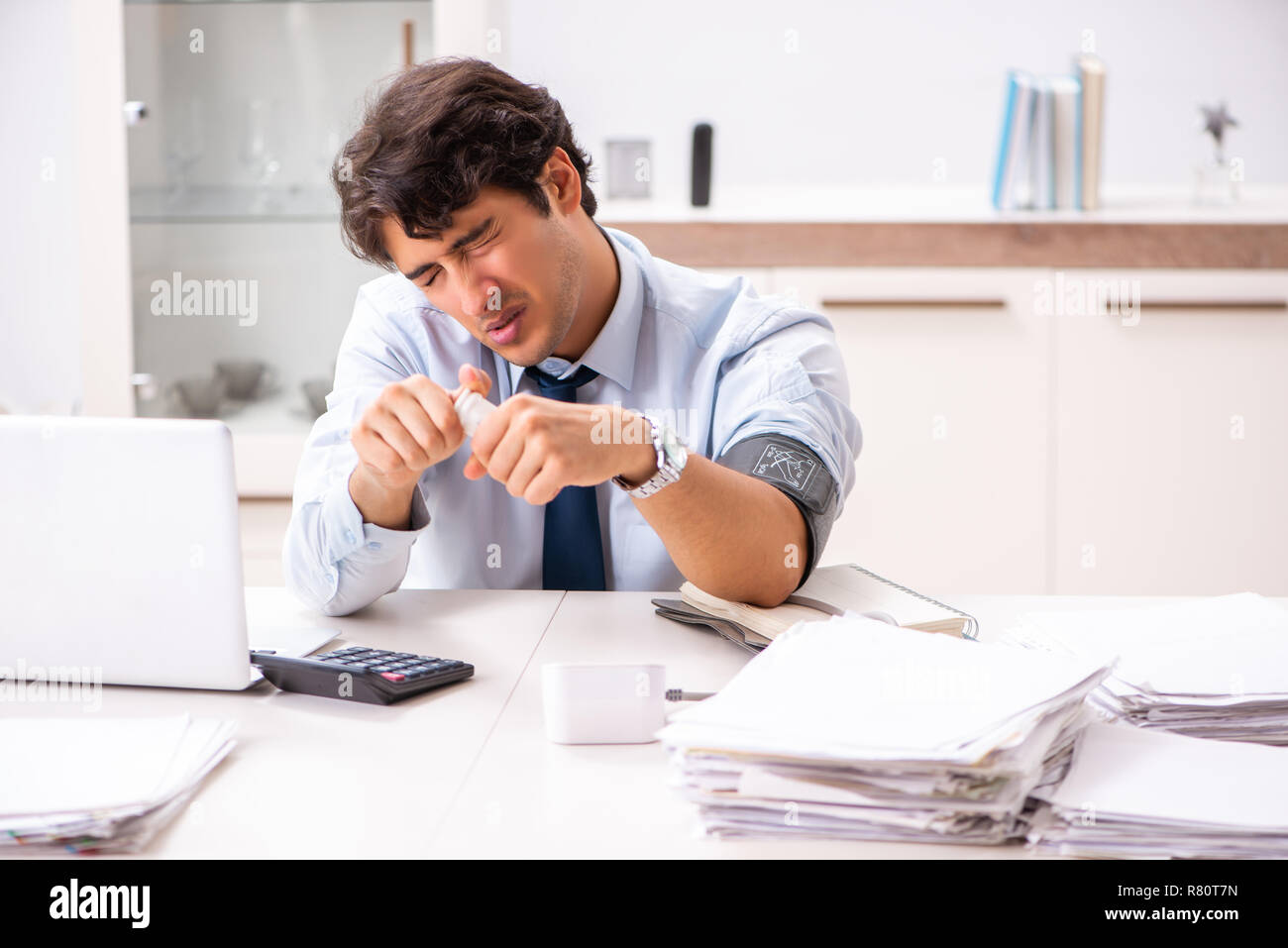 Man under stress measuring his blood pressure Stock Photo - Alamy