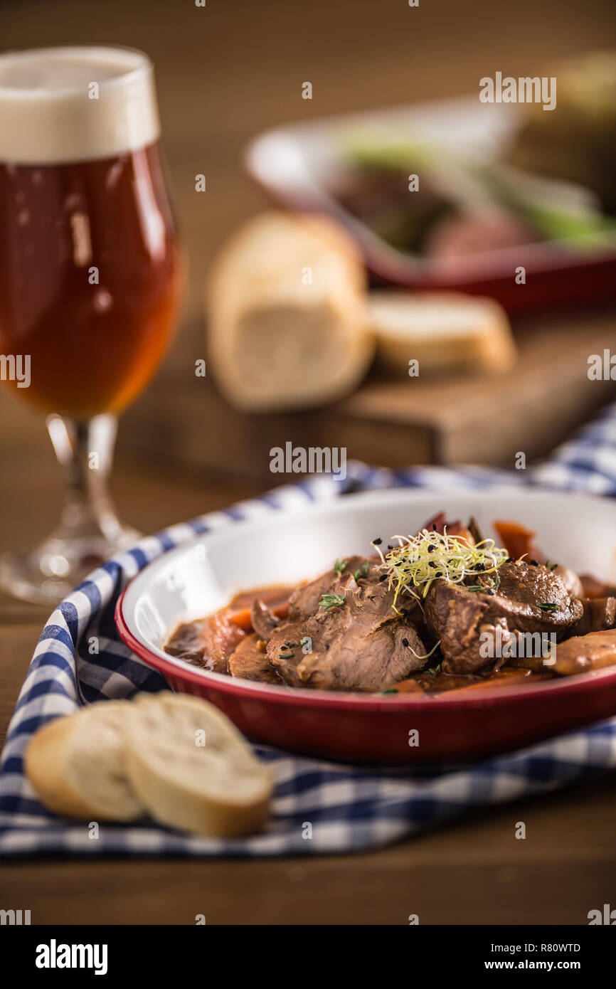 Roast wild boar with carrot mushrooms, baguette and draft beer Stock ...