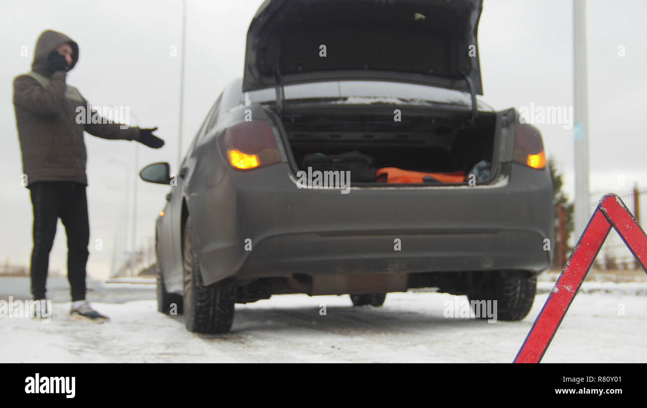 A car accident. A young man standing by a broken car. Catching a car ...