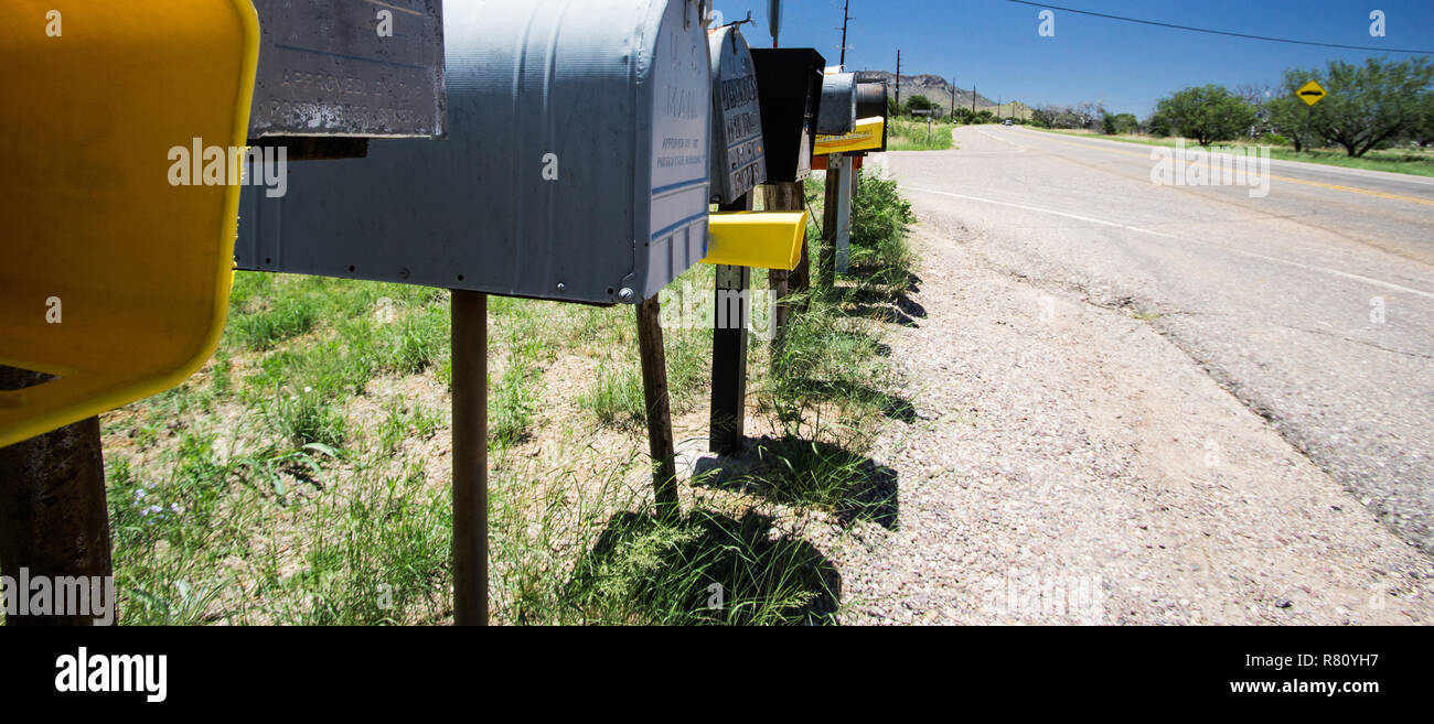 row of metal and plastic mailboxes on the side of a remote highway in ...