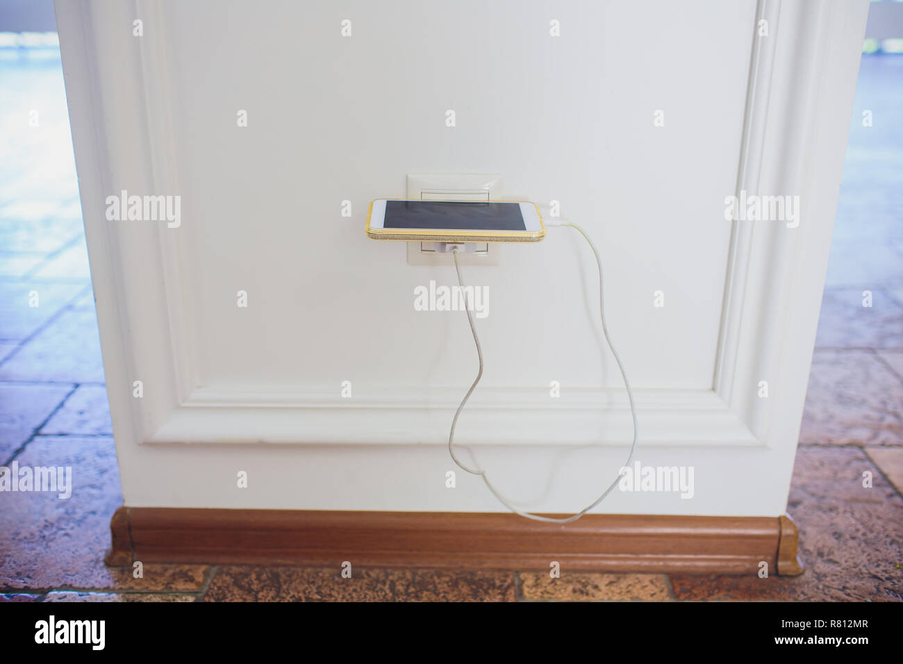 Loading batteries in a smart phone with socket and wall. Vertical Stock ...