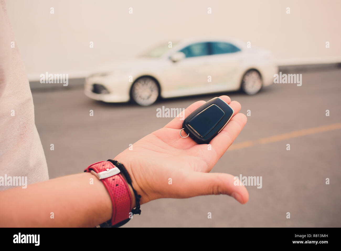 Male holding car keys with car background Stock Photo - Alamy