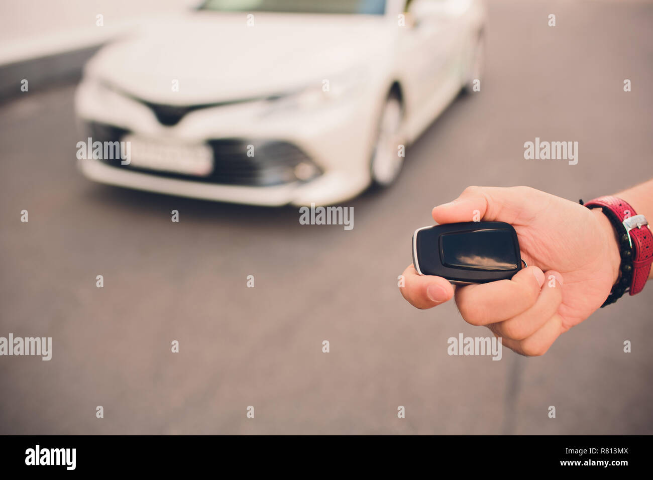 Male holding car keys with car background Stock Photo - Alamy