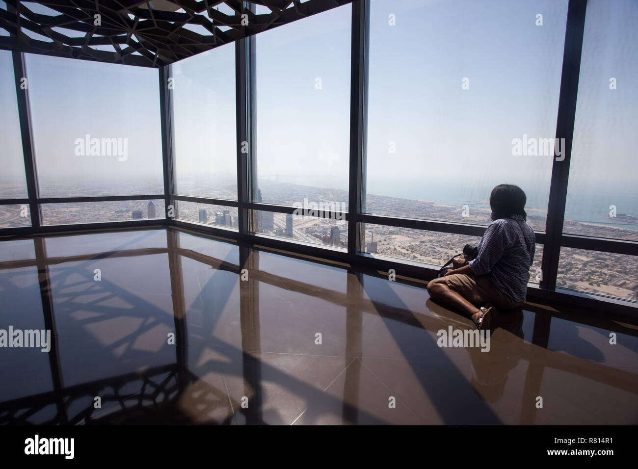 A female Indian tourist posts for photos at the Burj Khalifa's viewing ...