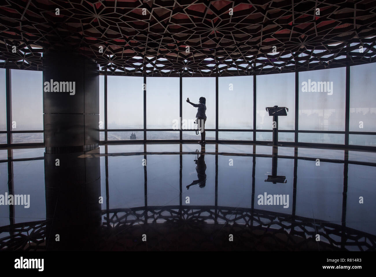 A female Indian tourist posts for photos at the Burj Khalifa's viewing ...