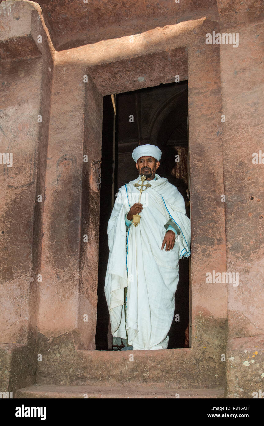 Priest holding a cross, at the monolithic rock-cut Church of Bete ...