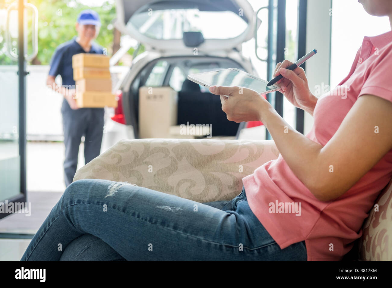 woman courier holding a parcel Shipping Mail appending signature ...