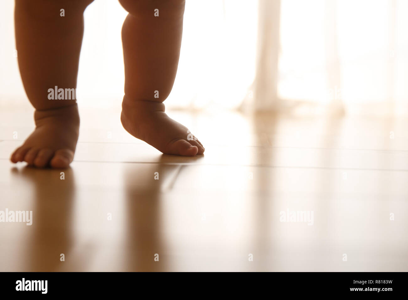 Baby learning to walk Stock Photo - Alamy