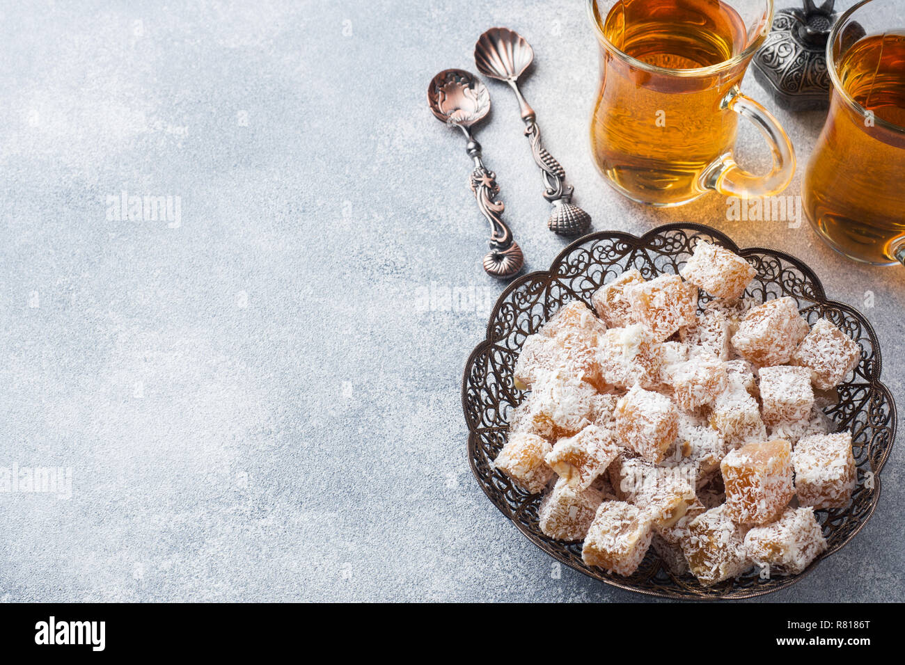 Turkish delight with hazelnut in carved metal bowl and tea in glass Cup ...