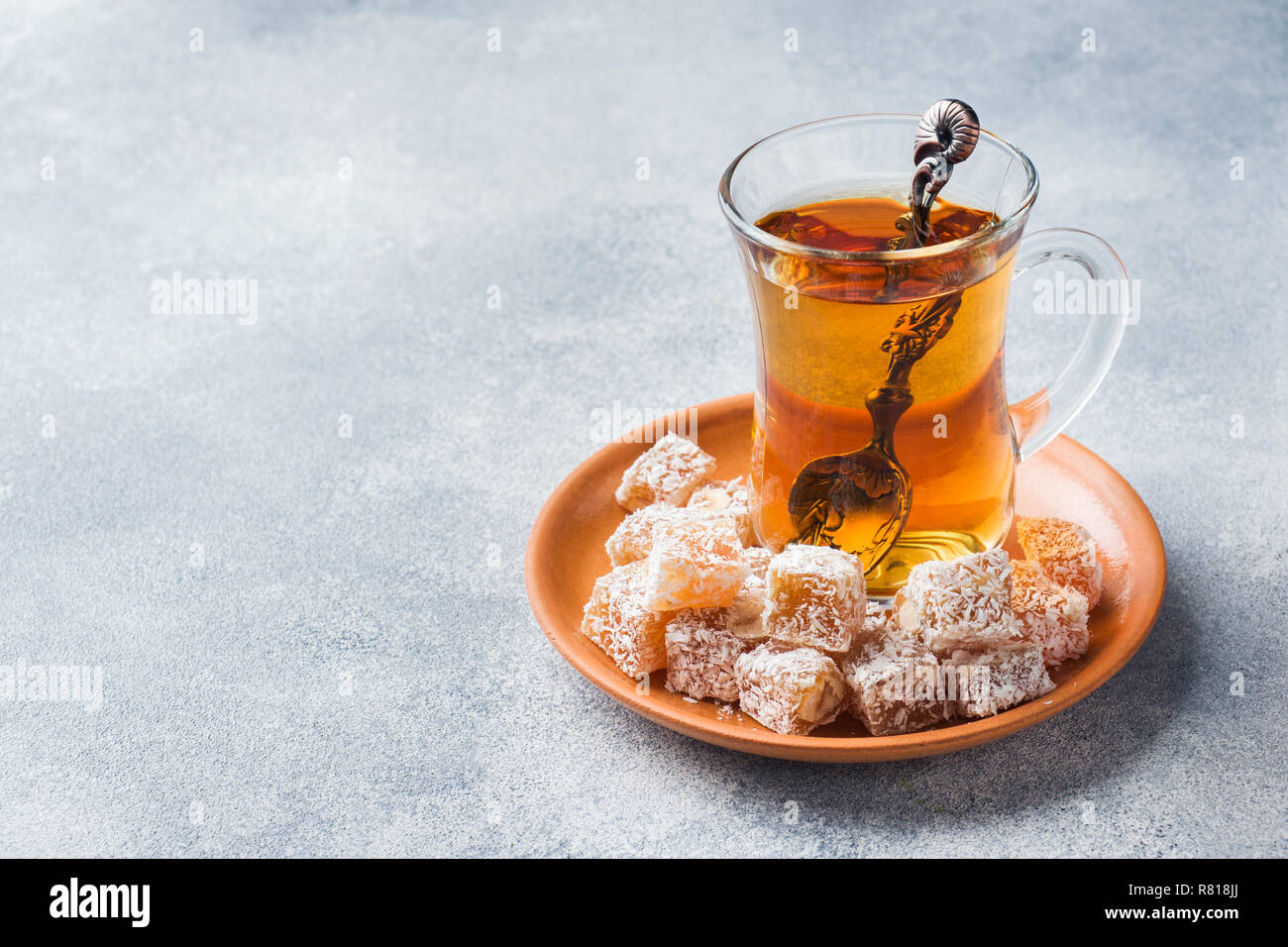 Turkish delight with hazelnut in carved metal bowl and tea in glass Cup ...