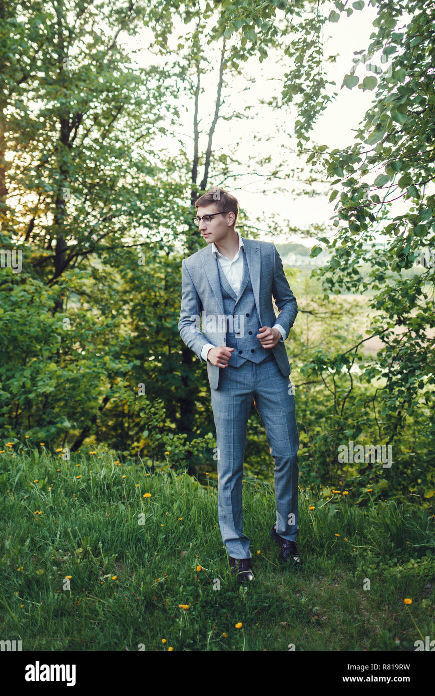 stylish groom in glasses and suit posing outdoors Stock Photo - Alamy