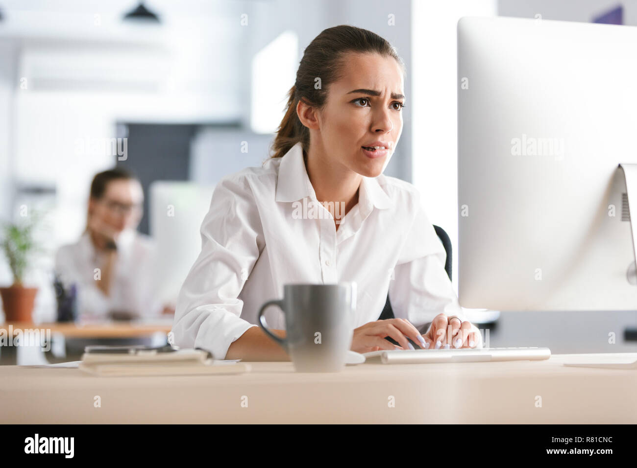 Photo of a confused business woman in office working with computer ...