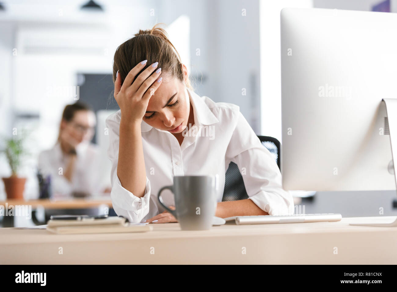 Photo of a sad tired business woman sitting in office working with ...
