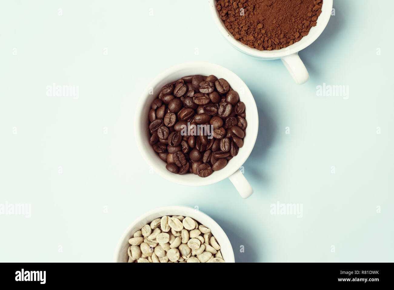 Different types of coffee - ground, grain and unroasted on blue pastel ...